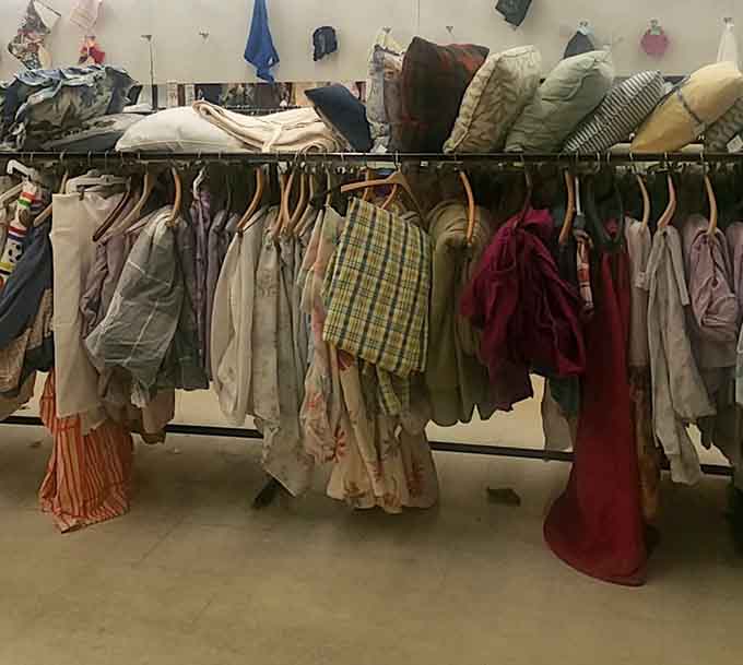 Bedding, pillows, and linens hanging on the rack, cozy home comforts available without the department store price tag attached.