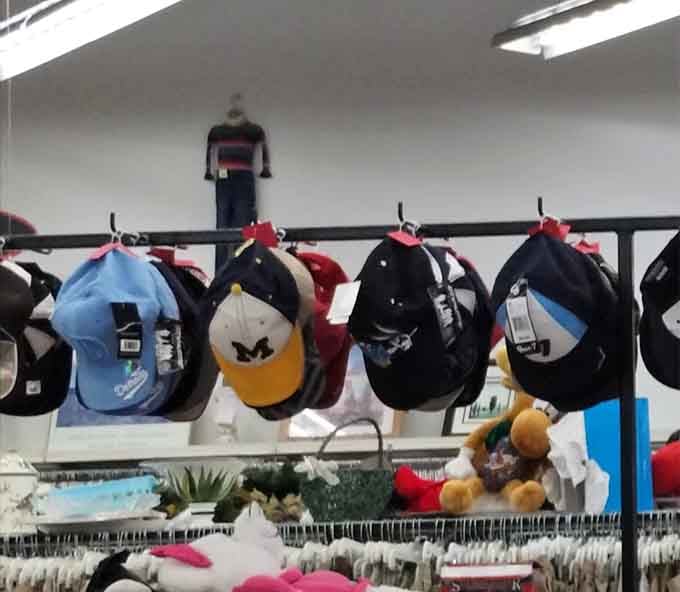 A Michigan Wolverines cap spotted among the lineup, proof that local pride shows up even at thrift stores.