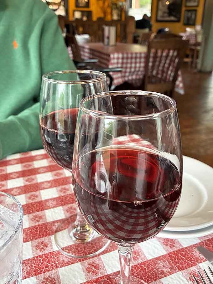 Red wine on checkered tablecloths—the visual definition of a perfect Italian-American dining experience.