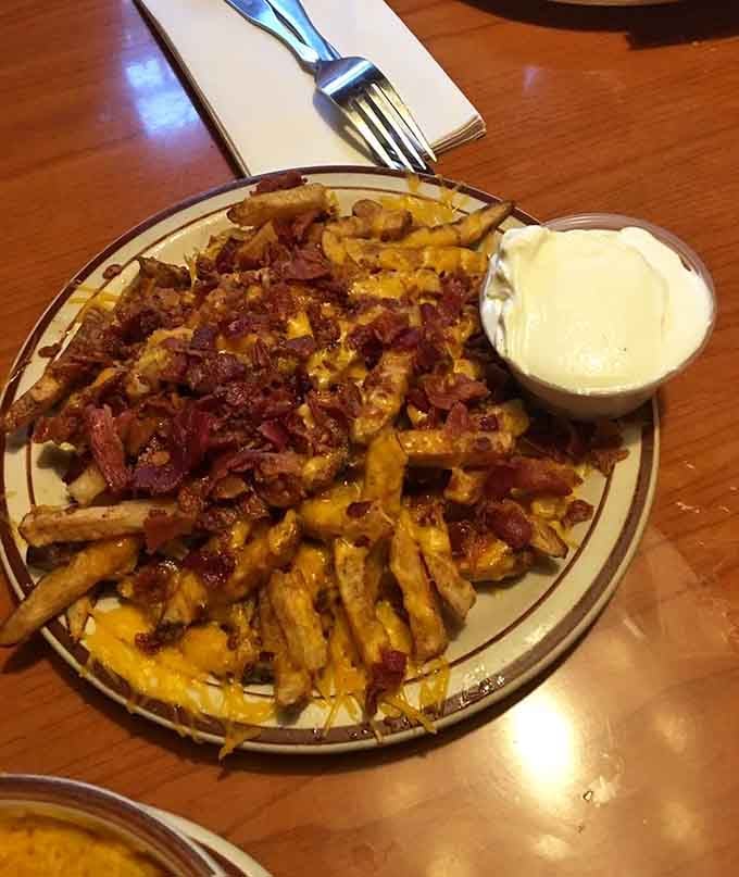 Bacon cheese fries with a side of creamy dipping sauce, the kind of appetizer that makes the table go completely silent.