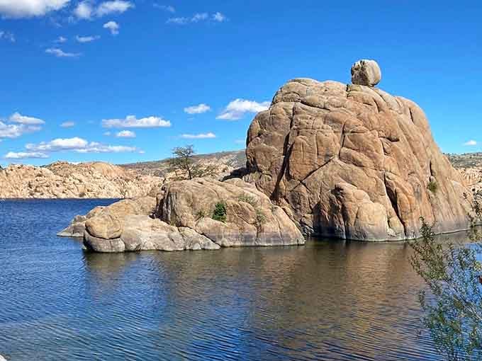 One enormous boulder balances perfectly above the water, unbothered, like it's been doing this since the beginning of time.