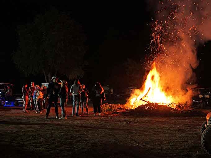 That bonfire reaches for the stars while campers gather round, creating memories that'll outlast any smartphone battery.