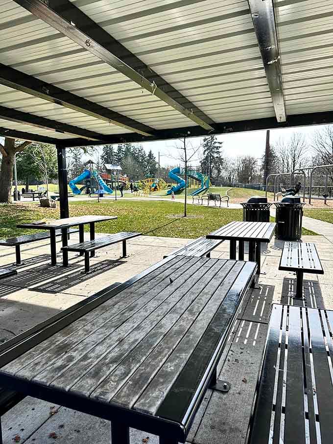 A covered picnic shelter with a front-row view of the playground means parents eat lunch without missing a single moment.