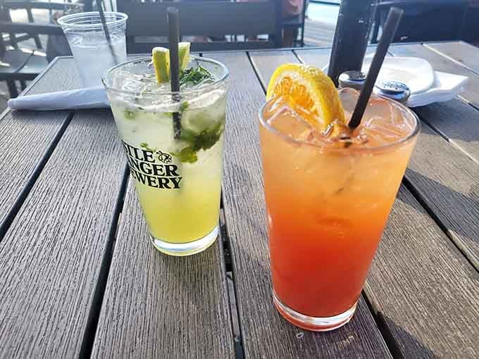 Two colorful cocktails sitting on the deck, looking like they belong on a postcard nobody ever wants to leave.