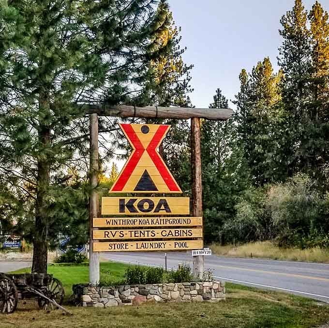 The KOA sign welcomes you to where RVs, tents, and covered wagons peacefully coexist in camping harmony.