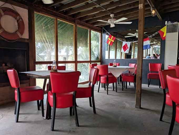 Bold red chairs against weathered wood walls, the dining room somehow makes rustic and cheerful feel like the same thing.
