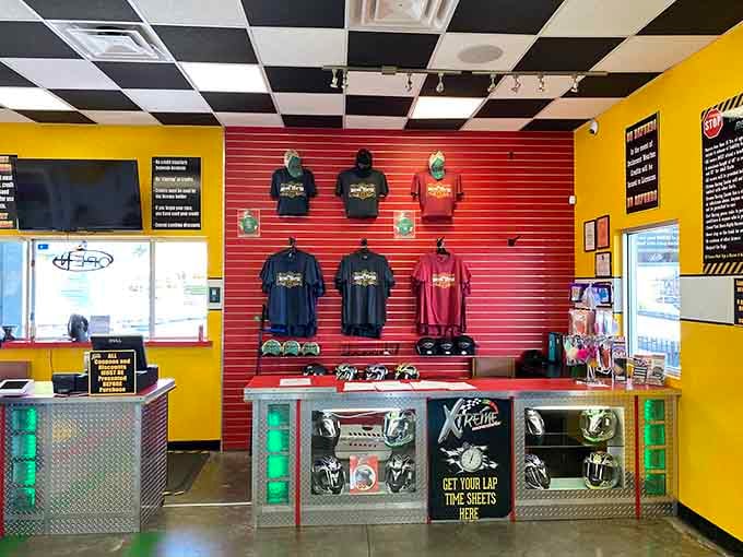 Bright yellow walls, racing gear on display, and your lap time sheet waiting at the counter. Trophy not included.