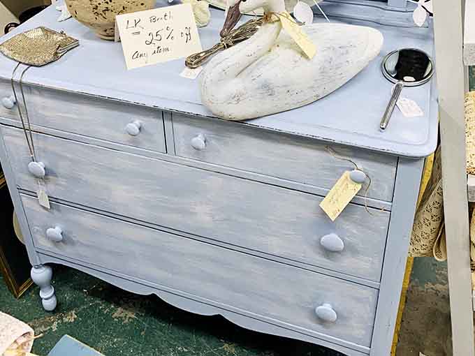 A chalky blue dresser with stone knobs sitting quietly, looking like it just stepped out of a French countryside farmhouse.