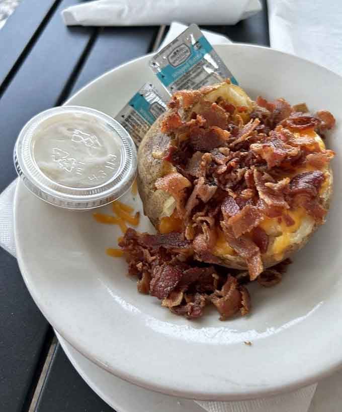 A loaded baked potato with enough bacon to make vegetarians question their life choices, at least momentarily anyway.