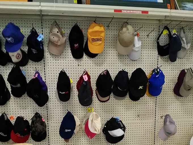 Baseball caps hanging like a hall of fame collection, each one ready to shield your head for less than a latte.