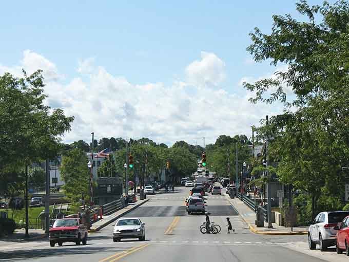 Charlevoix's bridge-straddling main street hums with summer energy, where bikes, flags, and good vibes share the road freely.