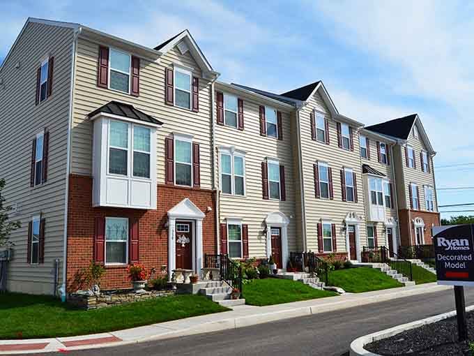 Neat townhomes line a sunny Lansdale street with fresh-cut lawns and tidy facades, the kind of neighborhood that makes you feel optimistic.