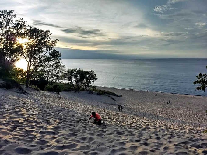 A lone figure climbs the Indiana Dunes at golden hour, with Lake Michigan stretching endlessly ahead — proof that Indiana saves its biggest surprises for last.