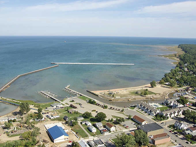 Port Austin's harbor stretches a long, graceful pier into Lake Huron's blue expanse, a peaceful spot where the horizon feels close enough to touch.
