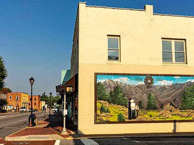 A vivid Waldensian heritage mural stretches across a cream-colored corner building, telling Valdese's remarkable immigrant story one brushstroke at a time.
