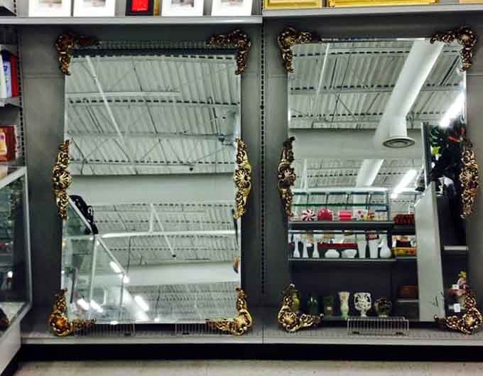 Two ornate gold-framed mirrors sitting side by side, the kind of elegant finds that look like they belong in a much fancier store.