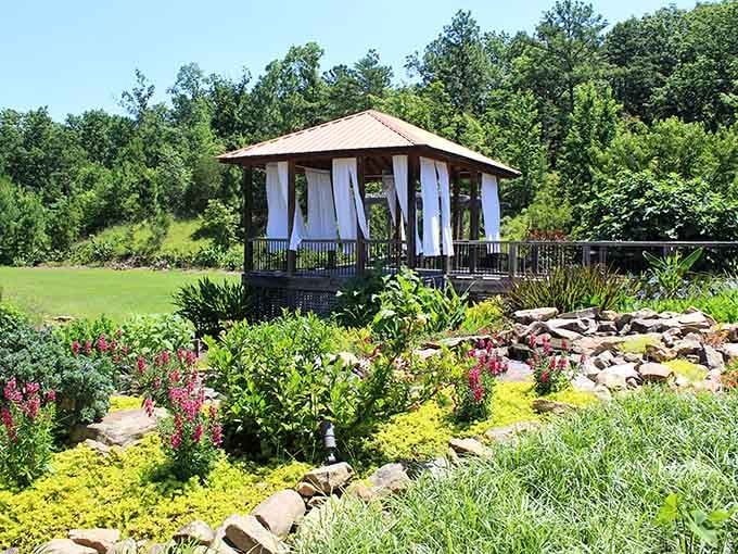 White curtains drift lazily in the breeze at this garden gazebo, practically begging you to slow down.