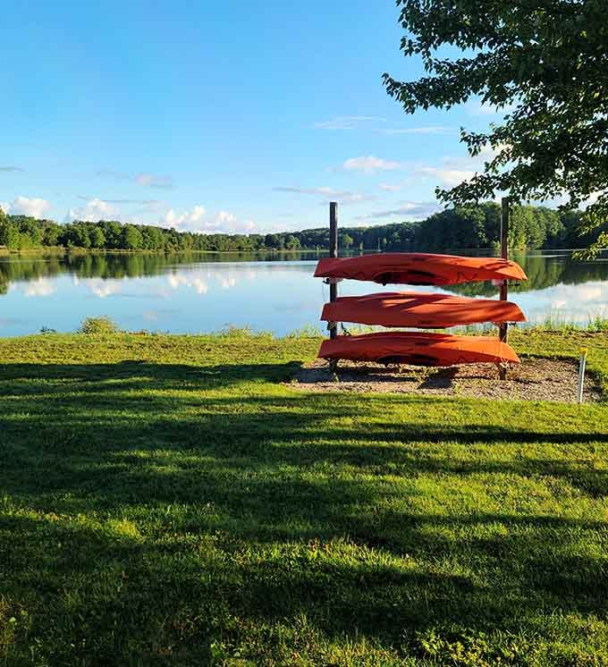 Three bright orange kayaks stacked and ready, because Sunny Lake isn't going to explore itself.