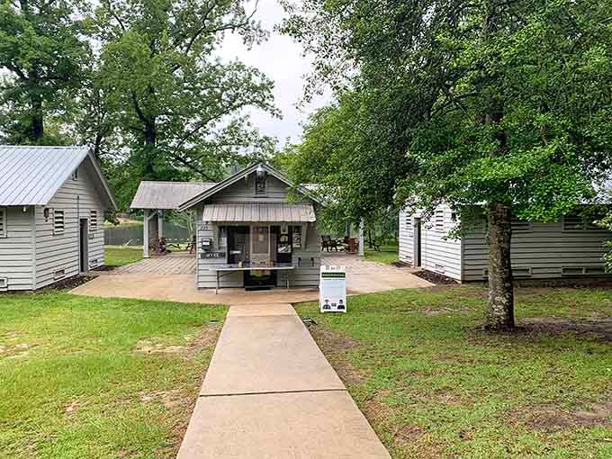 A charming cluster of gray cabins gathered around a central office, looking like the friendliest little neighborhood you never knew existed in Blackville.