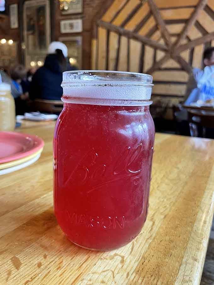 A vivid raspberry drink in a mason jar that looks as refreshing as a cool mountain breeze feels.