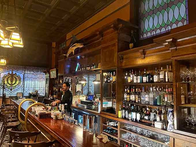That mahogany bar with stained glass panels behind it belongs in a museum. Lucky for you, it serves drinks instead.