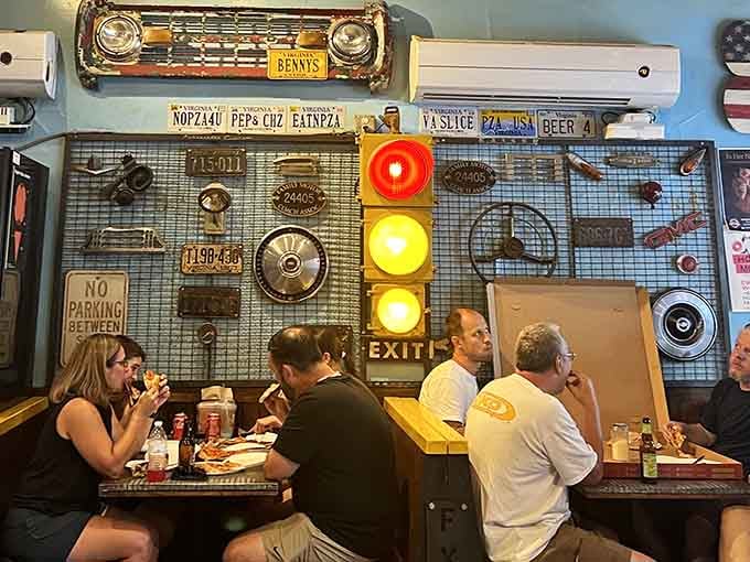 That working traffic light and vintage car parts create the perfect backdrop for serious pizza consumption.