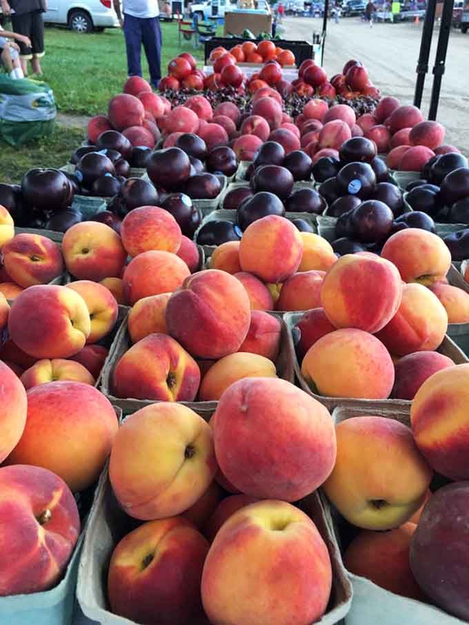 Sun-ripened peaches and plums piled high, looking like summer decided to show up and show off.