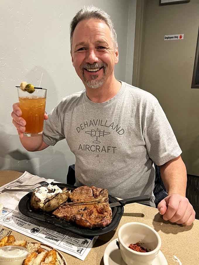 That smile says everything. A proper cocktail in hand, a sizzling steak in front of you, life is good.