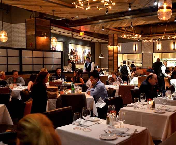The dining room buzzes with that perfect energy of people enjoying seriously good meals together.