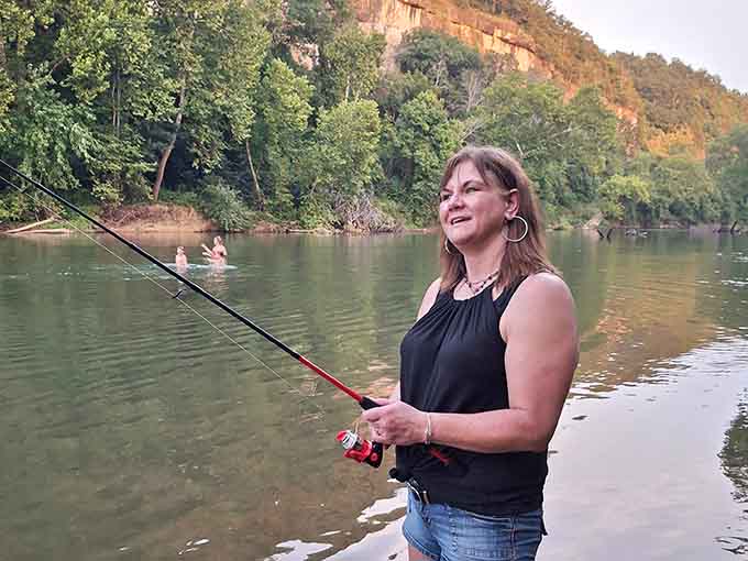 Fishing at Blue Springs Creek, with limestone bluffs glowing golden behind her. Not a bad office view.