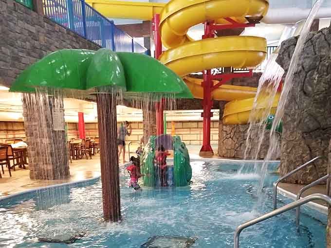 A rain umbrella feature and a spiraling yellow slide walk into a waterpark. Everyone wins.
