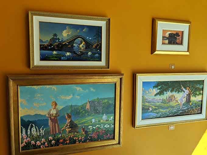 Original paintings hang on warm golden walls, turning a hallway into a quiet gallery worth slowing down for.