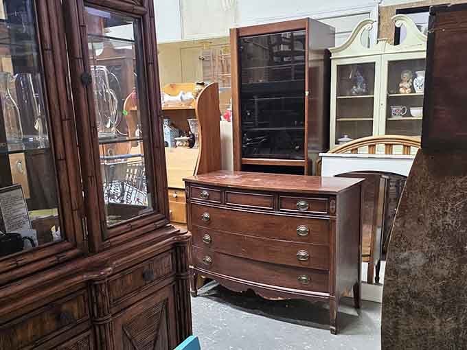 A bow-front dresser with glass-door cabinets nearby, solid craftsmanship that outlasted whoever gave it up.