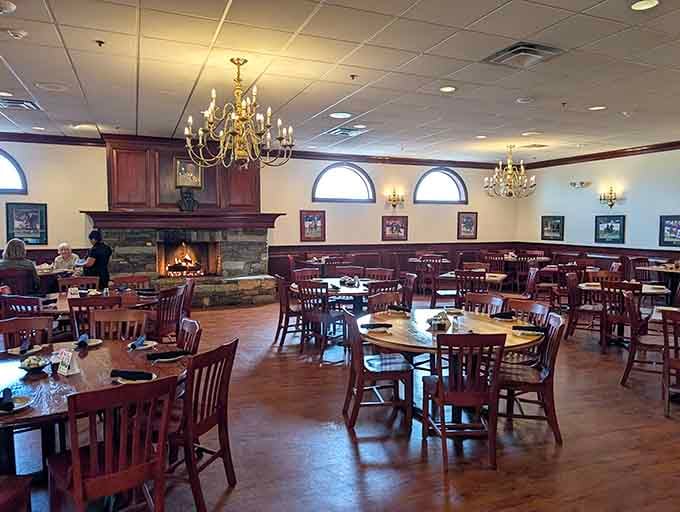 A crackling stone fireplace, warm chandeliers, and framed artwork on the walls. This dining room earns every single compliment it gets.