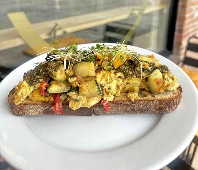 The daily scramble piled high on toast with sprouts, looking like a edible garden that actually tastes good.