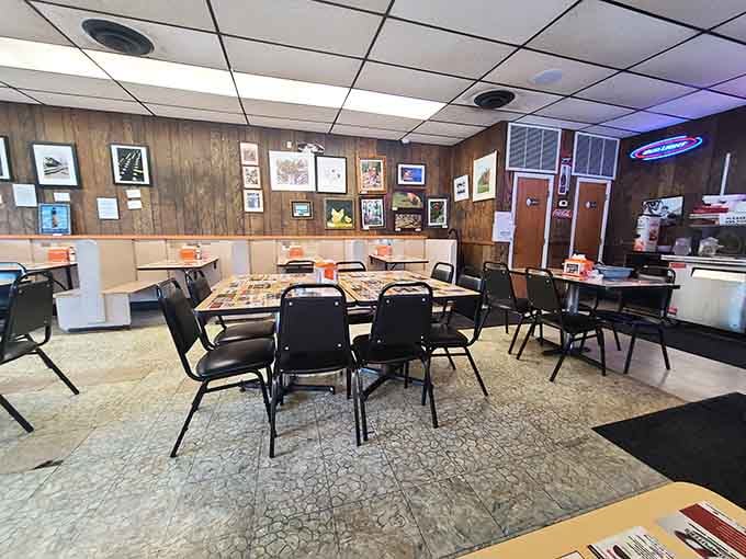 Framed artwork on wood-paneled walls and a Bud Light neon sign glowing in the corner. Perfection.