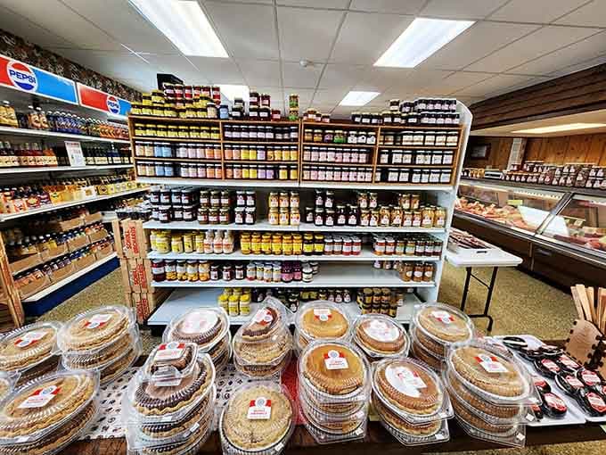 Homemade pies stacked in front of shelves bursting with jams and preserves — dessert and pantry solved simultaneously.