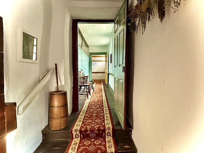 A narrow hallway with a red runner rug and dried herbs overhead. Every step here feels like walking through a living museum.