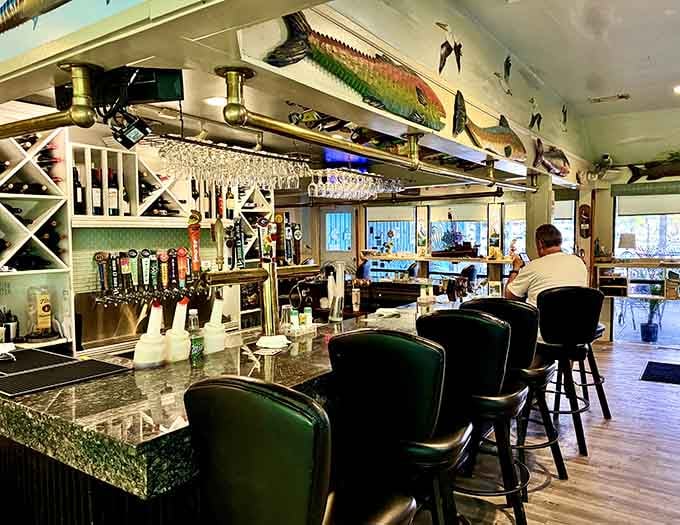 A well-stocked bar with fish mounted overhead and cold taps ready to pour. This is exactly where you want to be.