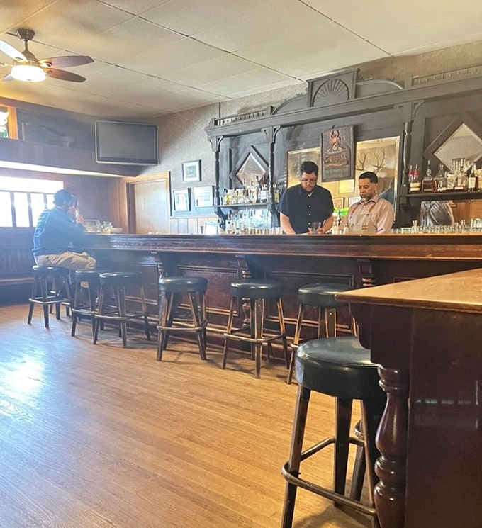 Behind the dark wooden bar, the staff keeps things moving. A well-run tavern has its own quiet rhythm.