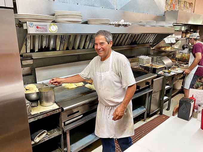 That smile behind the flat-top grill tells you everything: this kitchen runs on genuine pride, not just habit.
