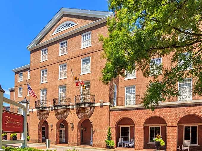 The Tidewater Inn's elegant brick exterior whispers Southern hospitality with every archway and hanging basket of flowers.