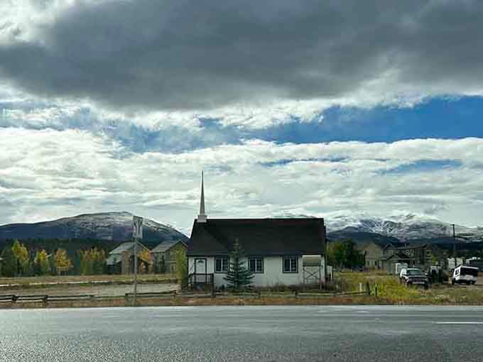 Small-town church against mountain backdrop reminds you why people chose to build lives in impossible places.