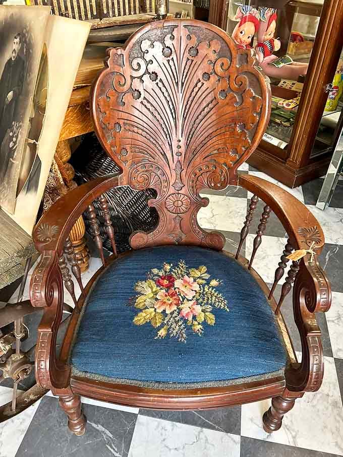 Victorian carved oak with needlepoint upholstery, the kind of chair that makes you sit up straight automatically.