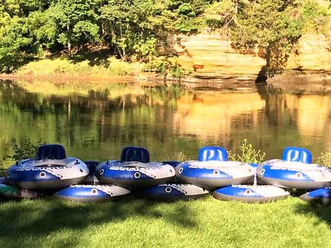 Rows of sturdy tubes rest on the grass with warm sandstone bluffs glowing behind them like a painted backdrop.