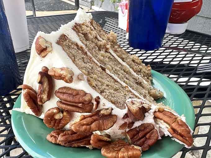 That cake slice stands tall and proud, loaded with pecans like it's auditioning for dessert stardom.