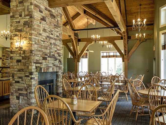 Stone fireplace, exposed timber beams, chandelier glow. This dining hall makes every meal feel like a celebration worth lingering over.