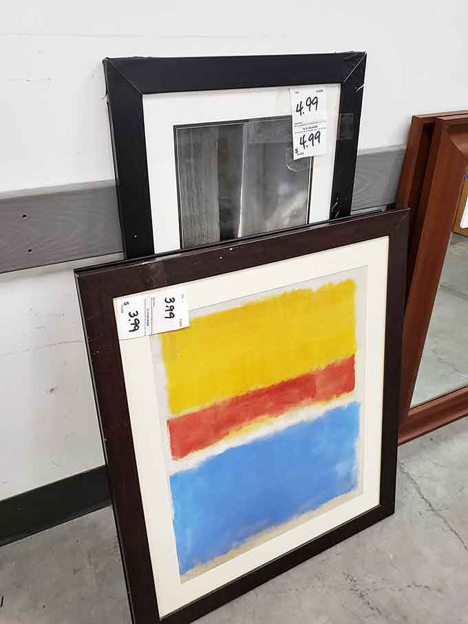 Framed art leaning against the wall, including a bold color-block print that looks like it belongs in a downtown gallery.