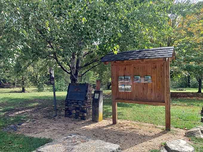 A wooden information board and stone marker stand ready to brief you, like a very calm, very knowledgeable park ranger who never takes a day off.