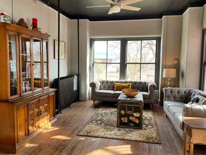 Tufted sofas, a vintage trunk, and afternoon light spilling across old hardwood floors. This room has stories.